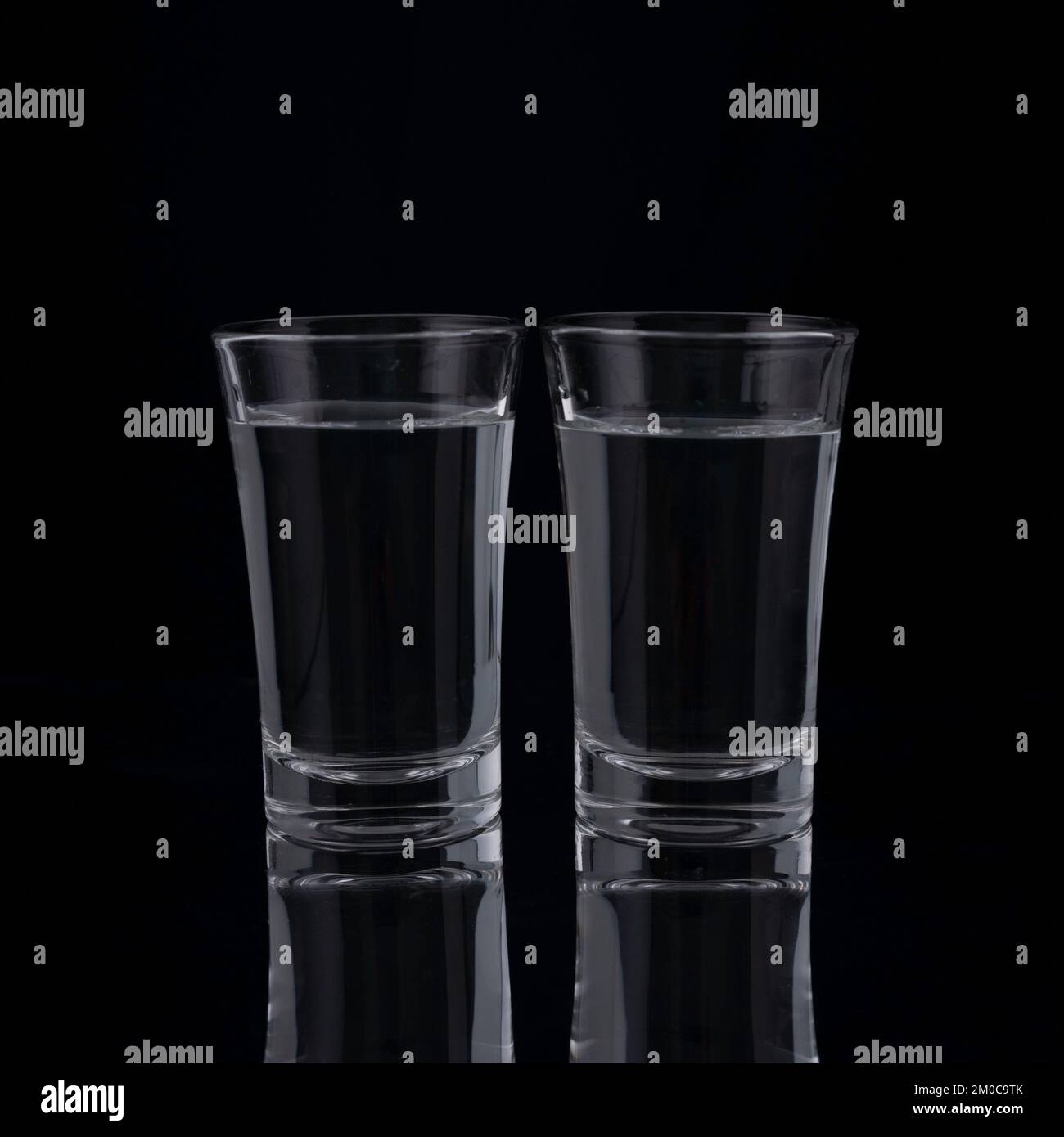 shot glasses with vodka on a black background Stock Photo - Alamy