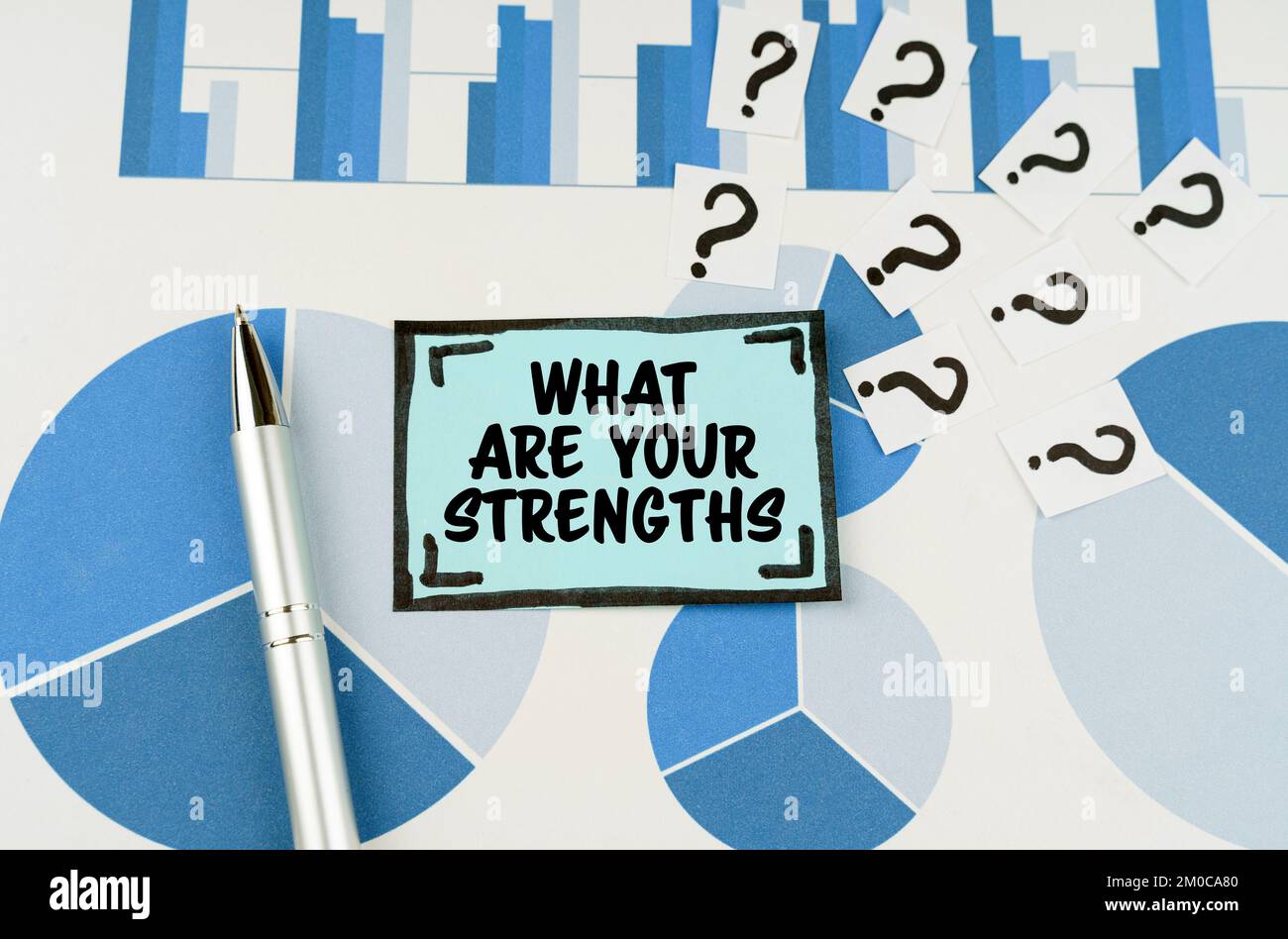 business question concept. On the blue diagrams lies a pen, questions ...