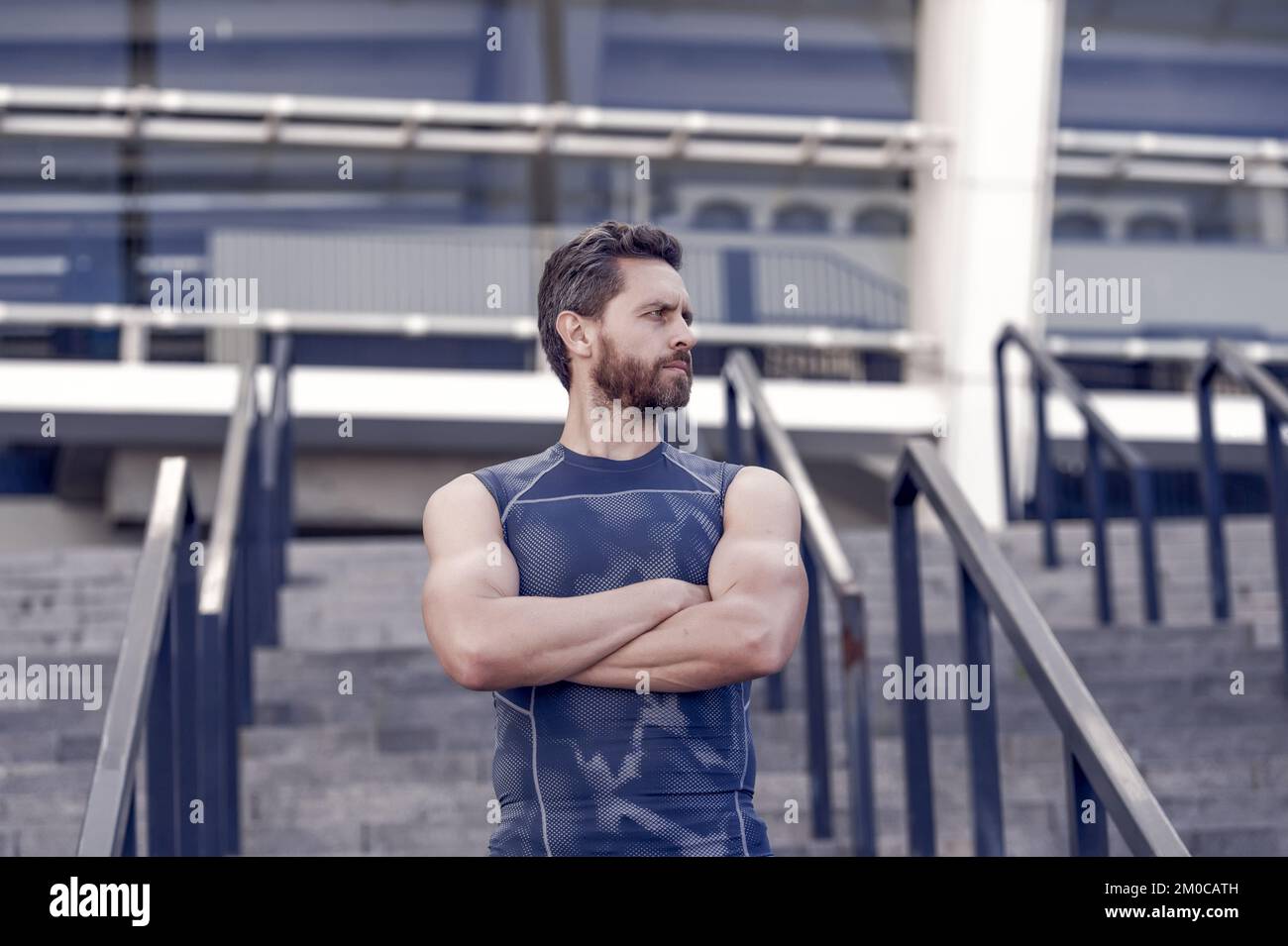 Man muscular fitness coach waiting on stairs stadium entrance ...