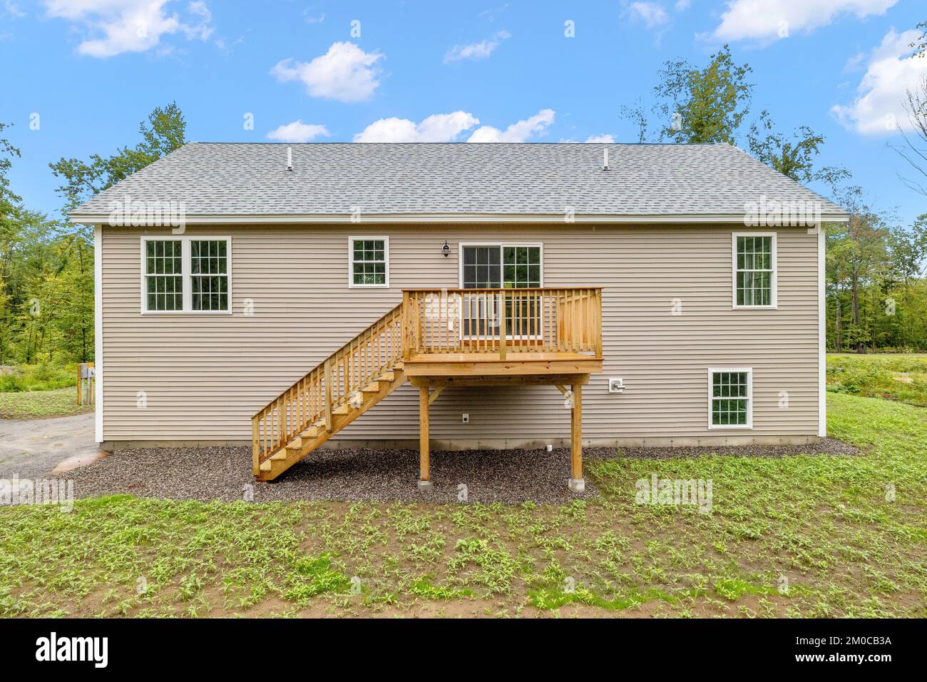 A grey modern construction of contemporary raised ranch surrounded by ...