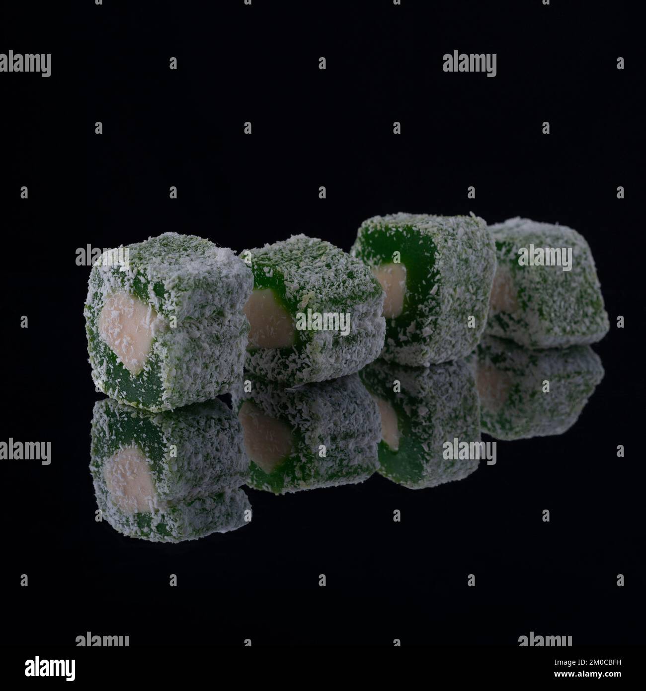 Turkish delight green sweets rolls on black background with coconut ...