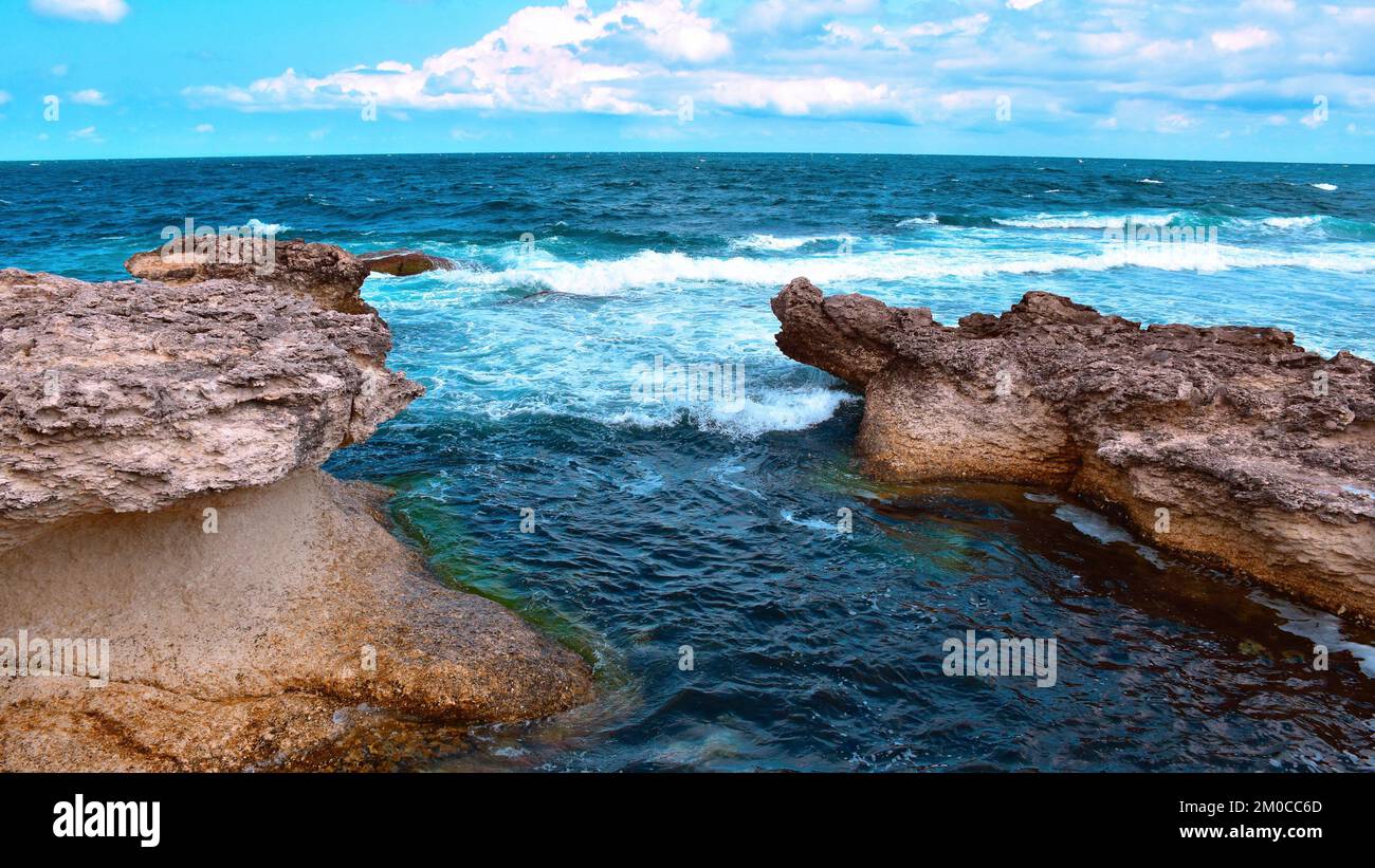 A beautiful seascape with rocky coastline, undulating sea under blue ...
