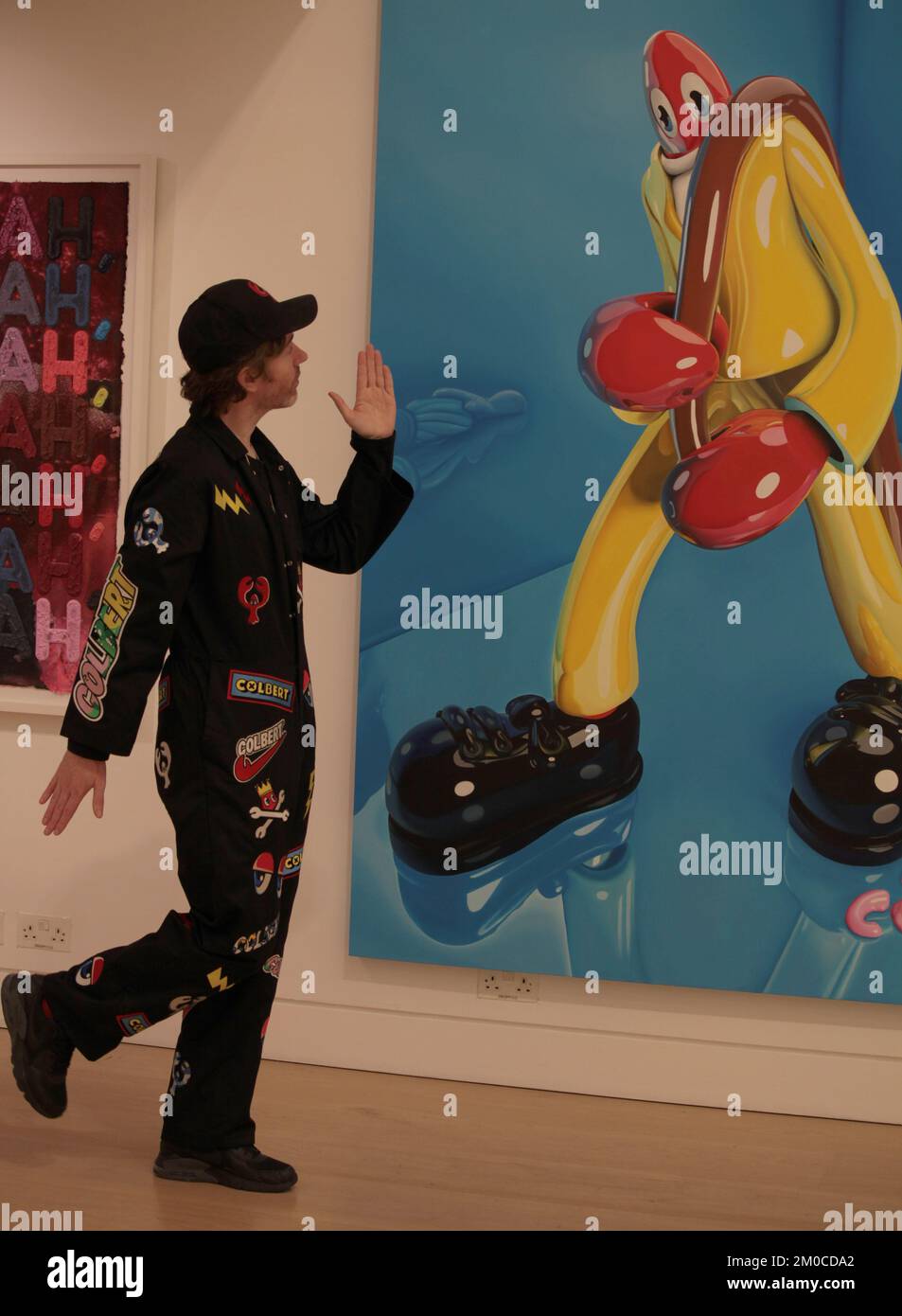 London, UK. Philip Colbert with one of his paintings at the auction ...