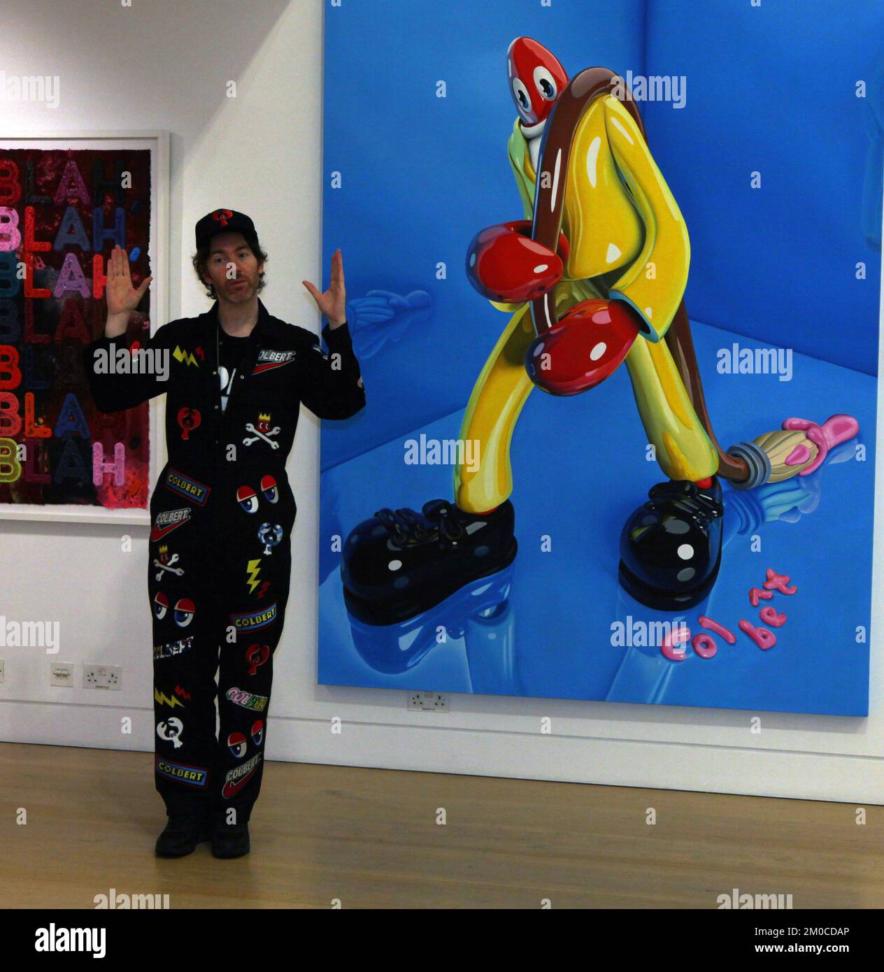 London, UK. Philip Colbert with one of his paintings at the auction ...