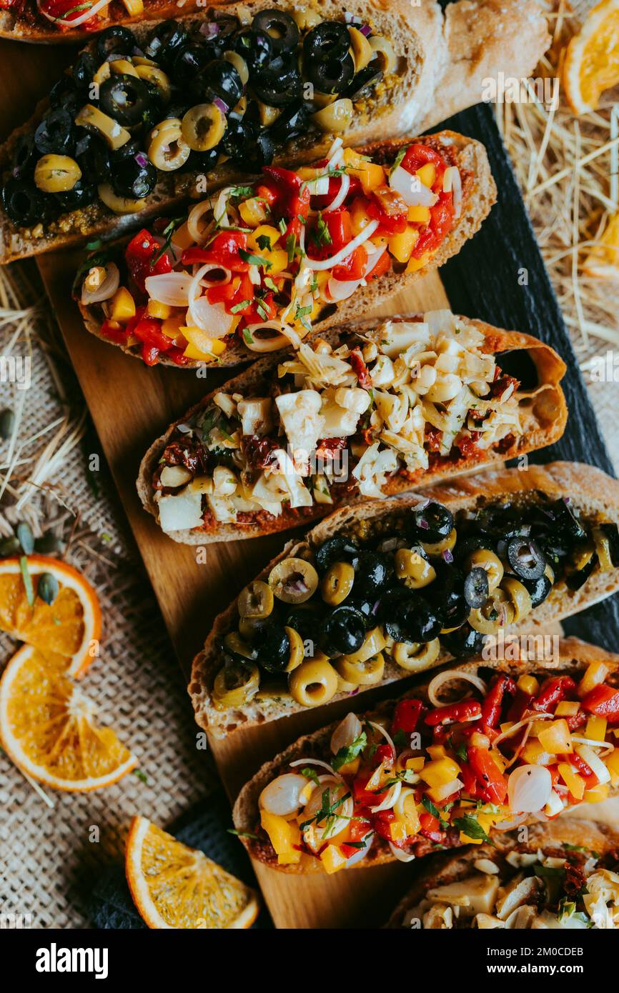 A vertical shot of bruschetta set with vegetables, mushrooms, and ...