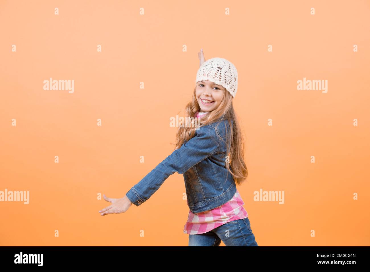 Child in jeans suit, hat, plaid shirt on orange background Stock Photo ...