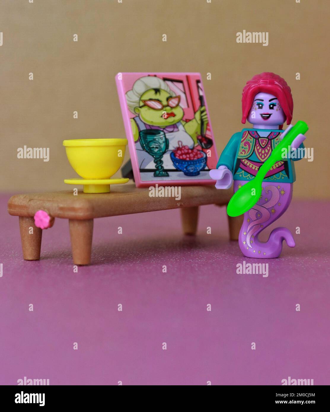 A vertical shot of a toy female-octopus character cooking in a kitchen ...