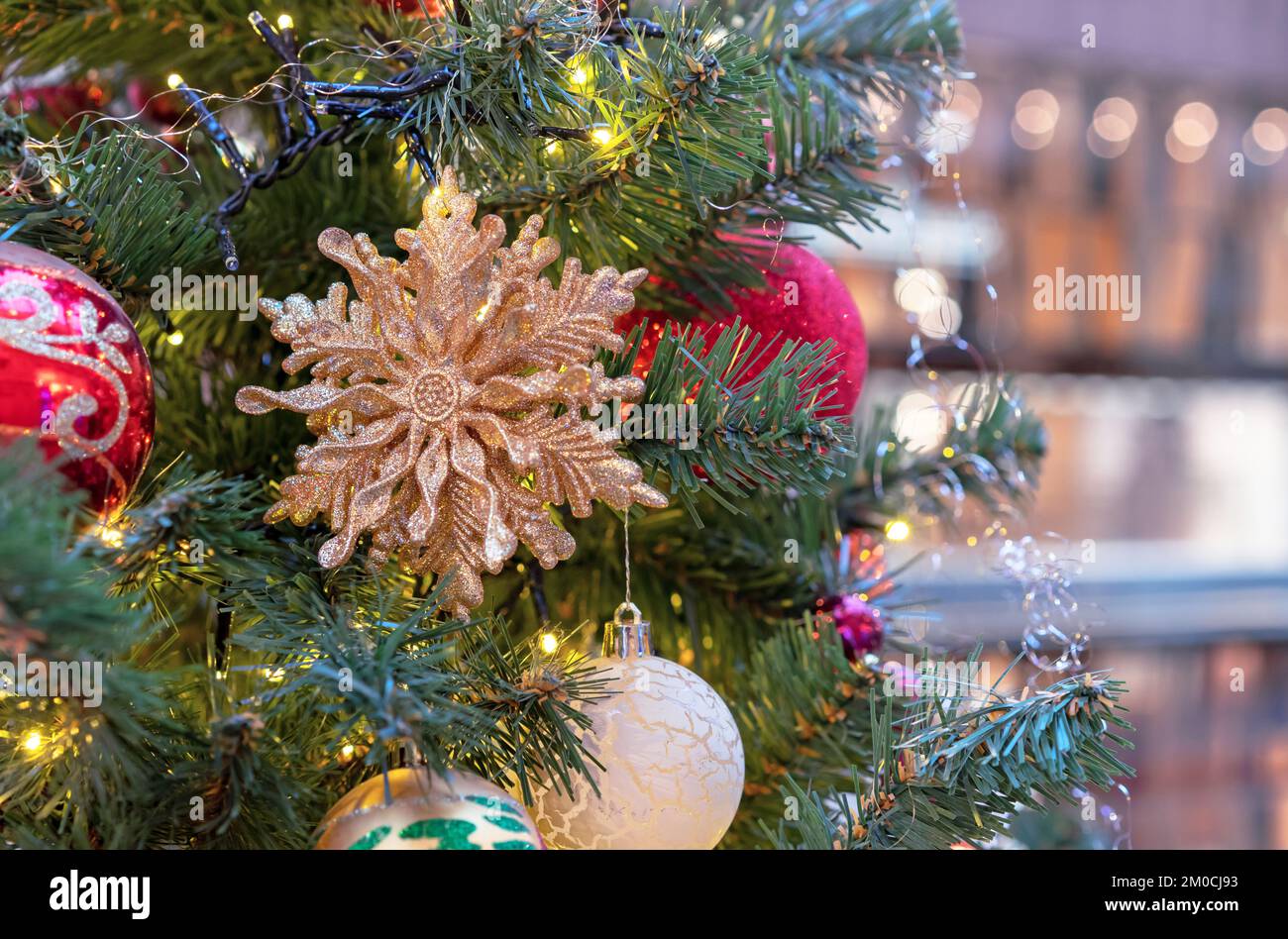 Snowflake with golden sparkles on the Christmas tree with Christmas ...