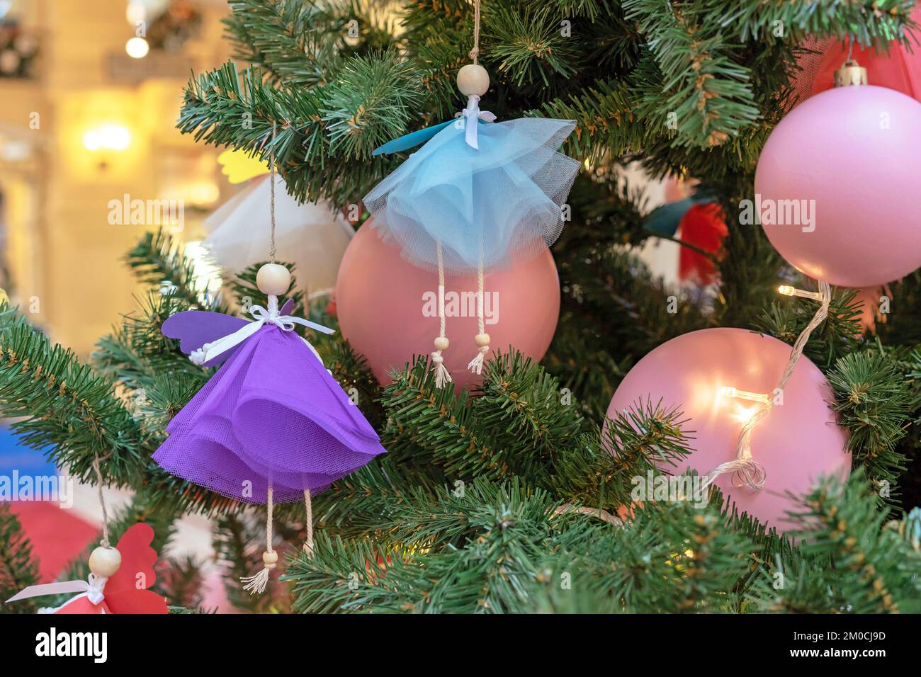 Angel dolls in multi-colored outfits on the Christmas tree Stock Photo ...