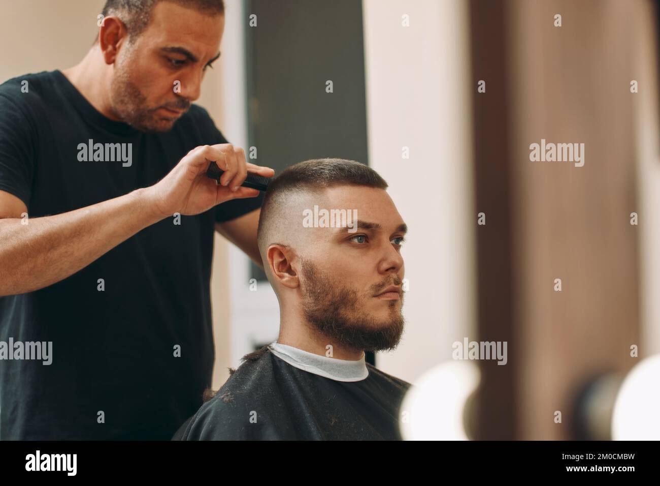 hairdresser does hairstyle with scissors in barber shop Stock Photo - Alamy