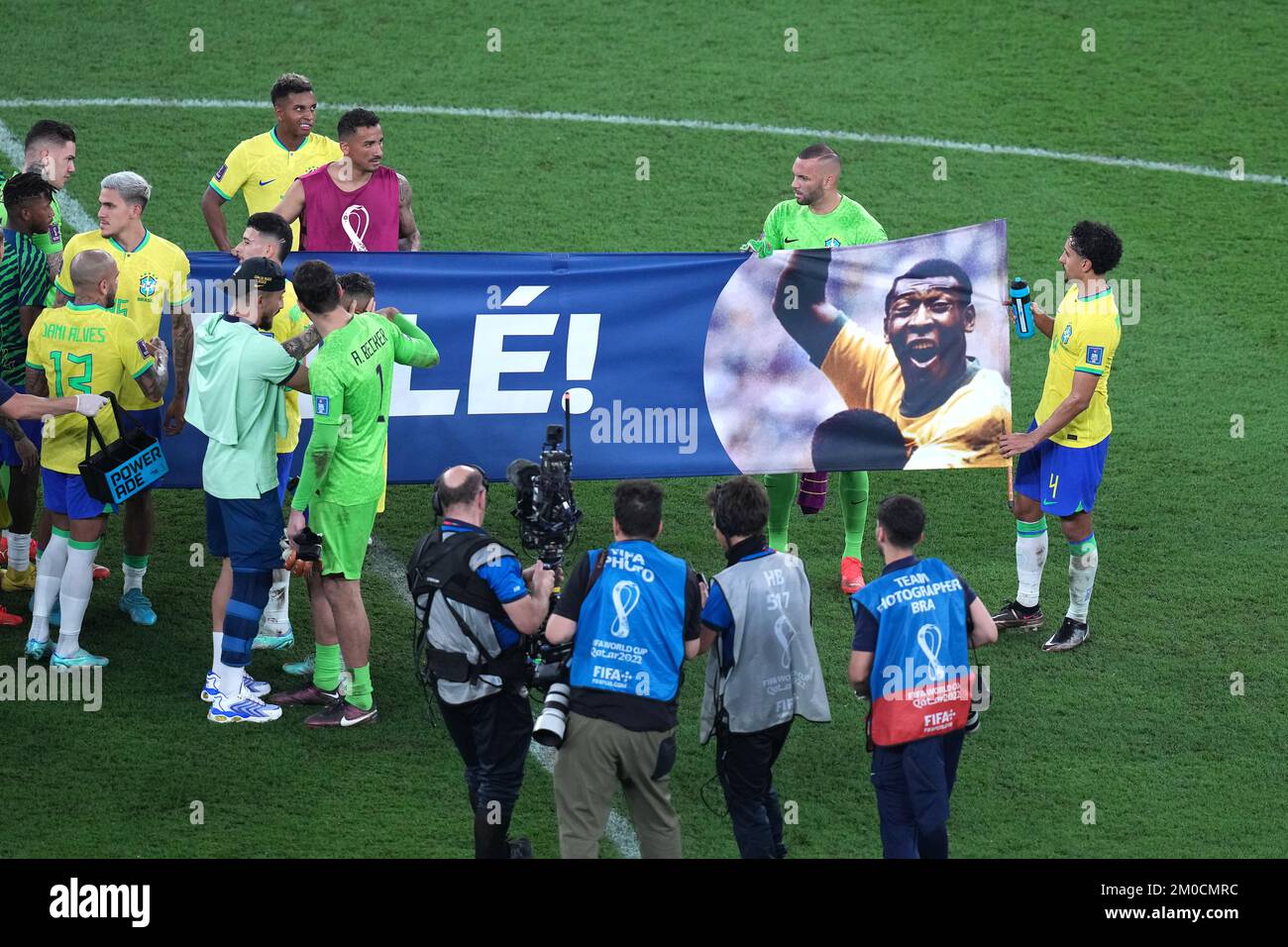 Brazil players hold up a banner for former player Pele after the final ...