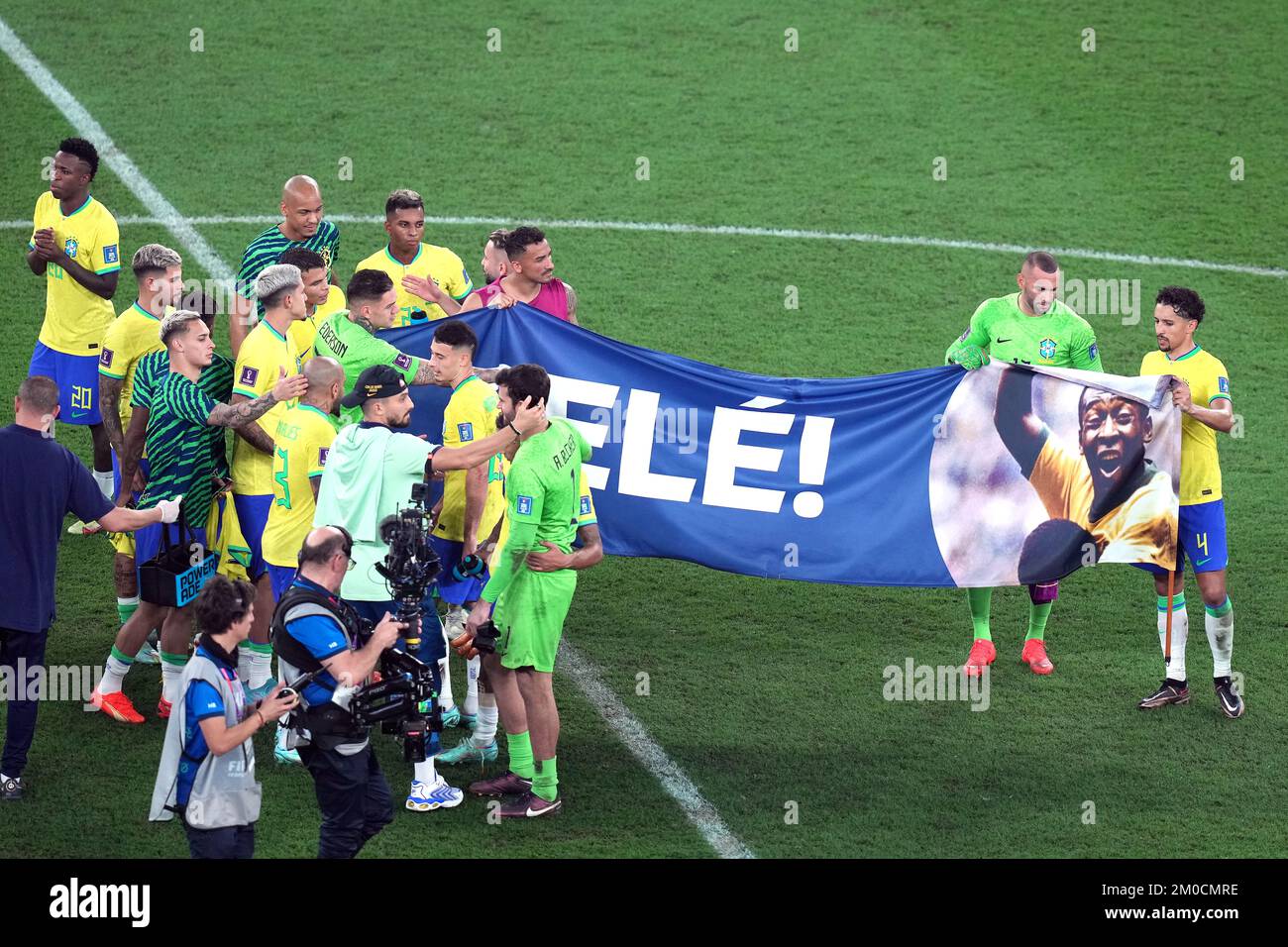 Brazil players hold up a banner for former player Pele after the final ...