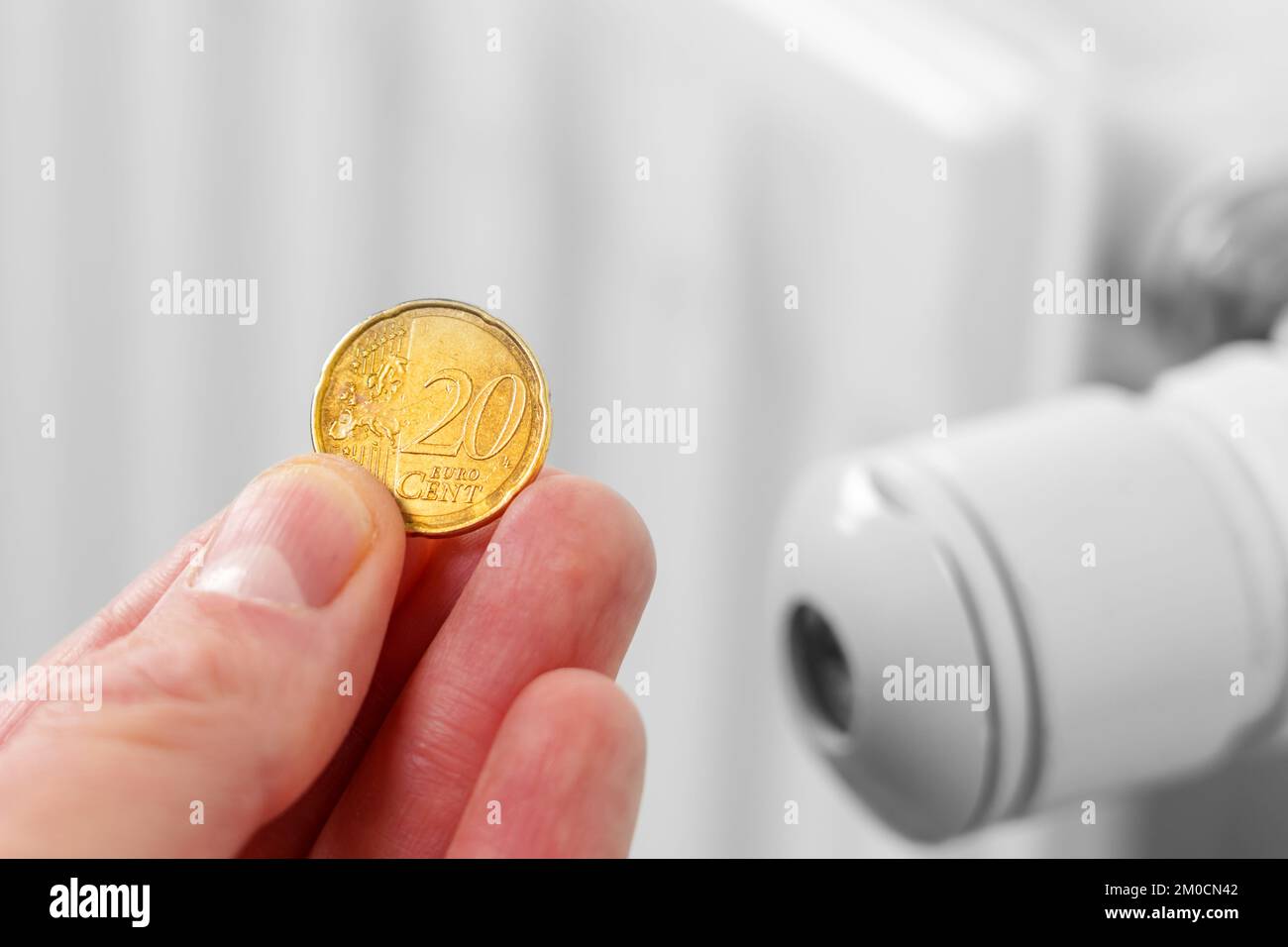 Coin in hand with a heating radiator thermostat. The concept of the ...