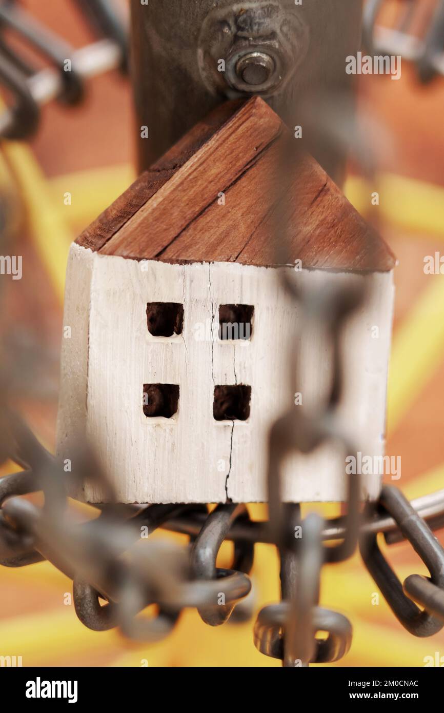 Wooden miniature house closed with chains and cracked damaged facade ...