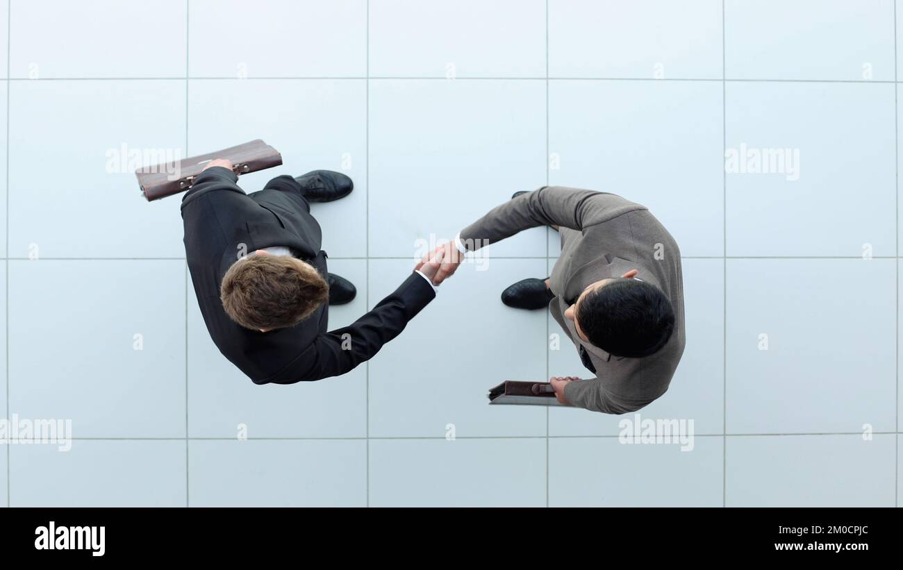 Business partners shaking hands as a symbol of unity, view from the top ...