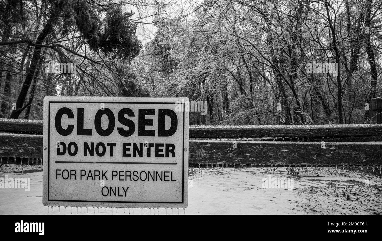 A grayscale of a sign with the text closed, do not enter in front of a ...