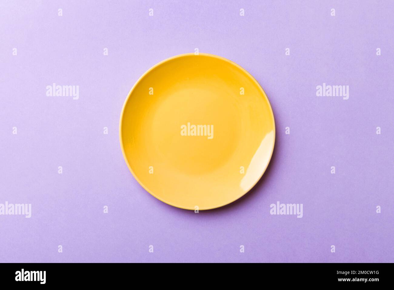 Top view of isolated of colored background empty round yellow plate for ...