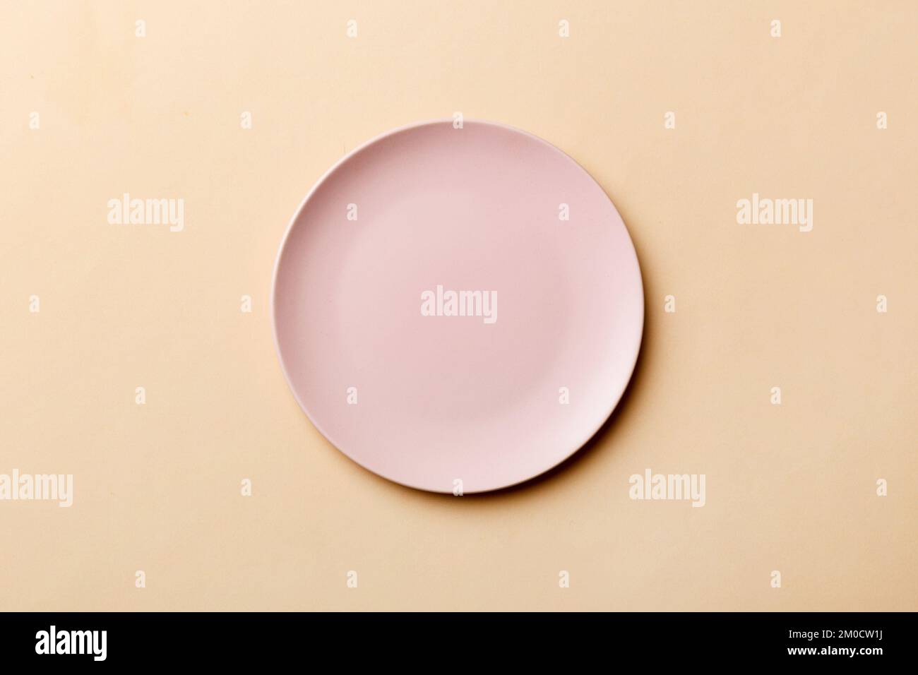 Top view of isolated of colored background empty round pink plate for ...