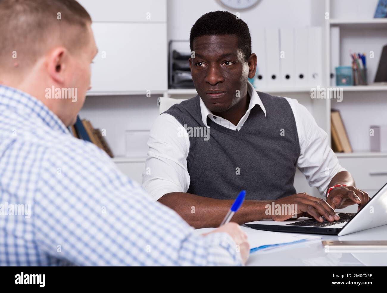 Confident business man working with partner in office Stock Photo - Alamy