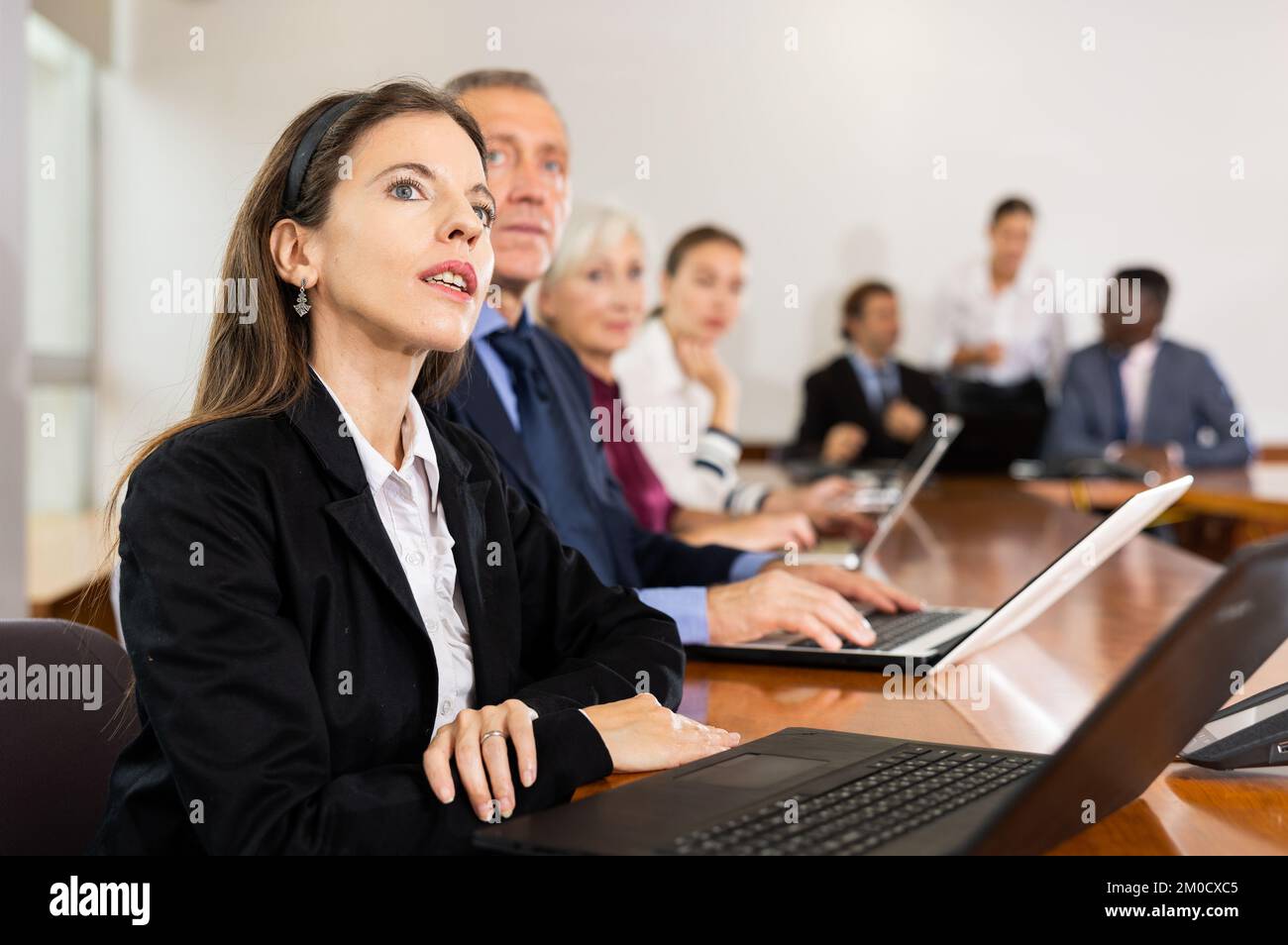 Woman secretary using laptop during conference Stock Photo - Alamy