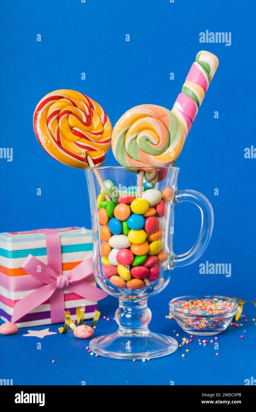 Colorful candies in cup on table on light background background. Large ...