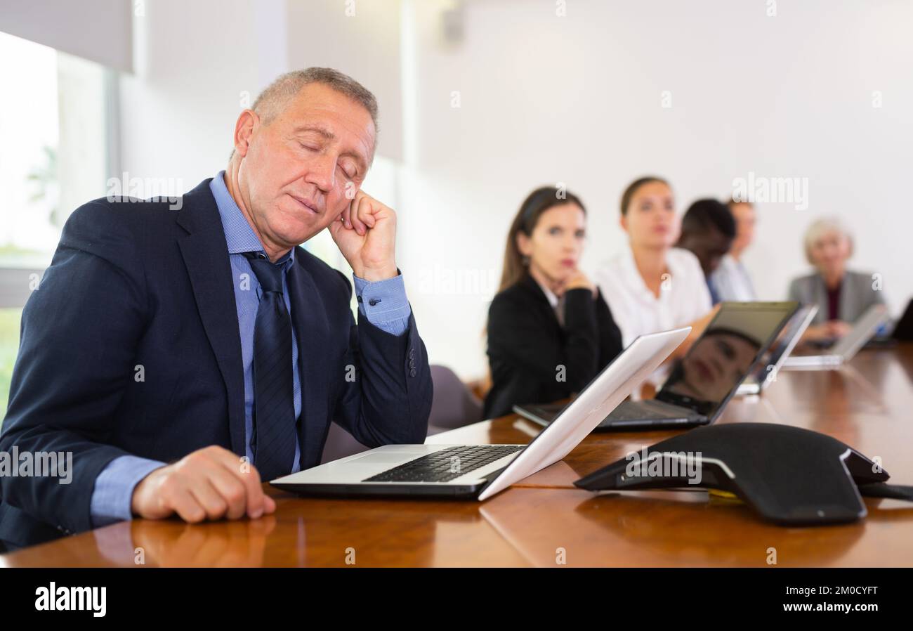 Mature businessman fell asleep at a business meeting in negotiation ...