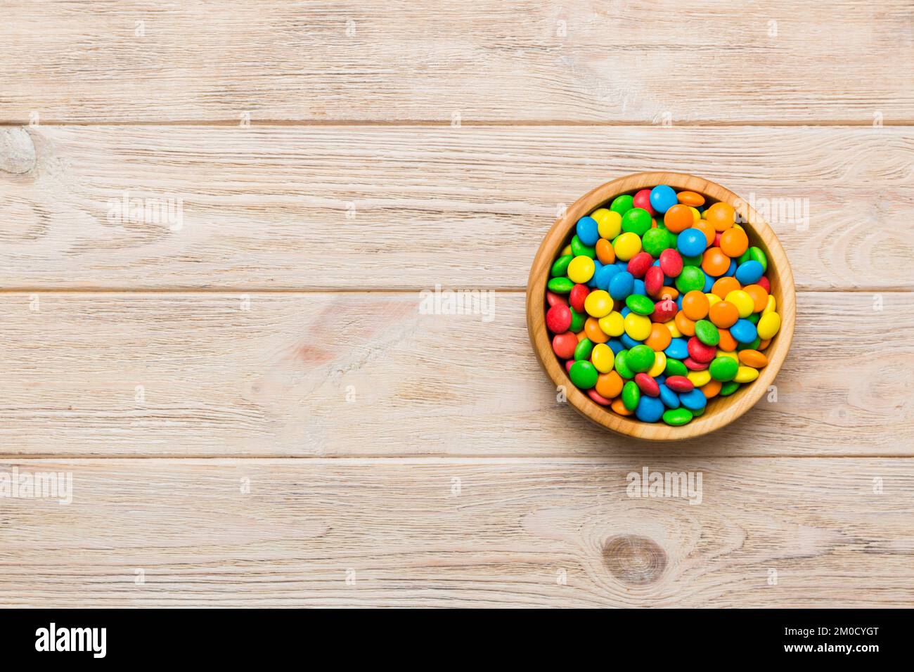 Multicolored candies in a bowl on a colored background. birthday and ...