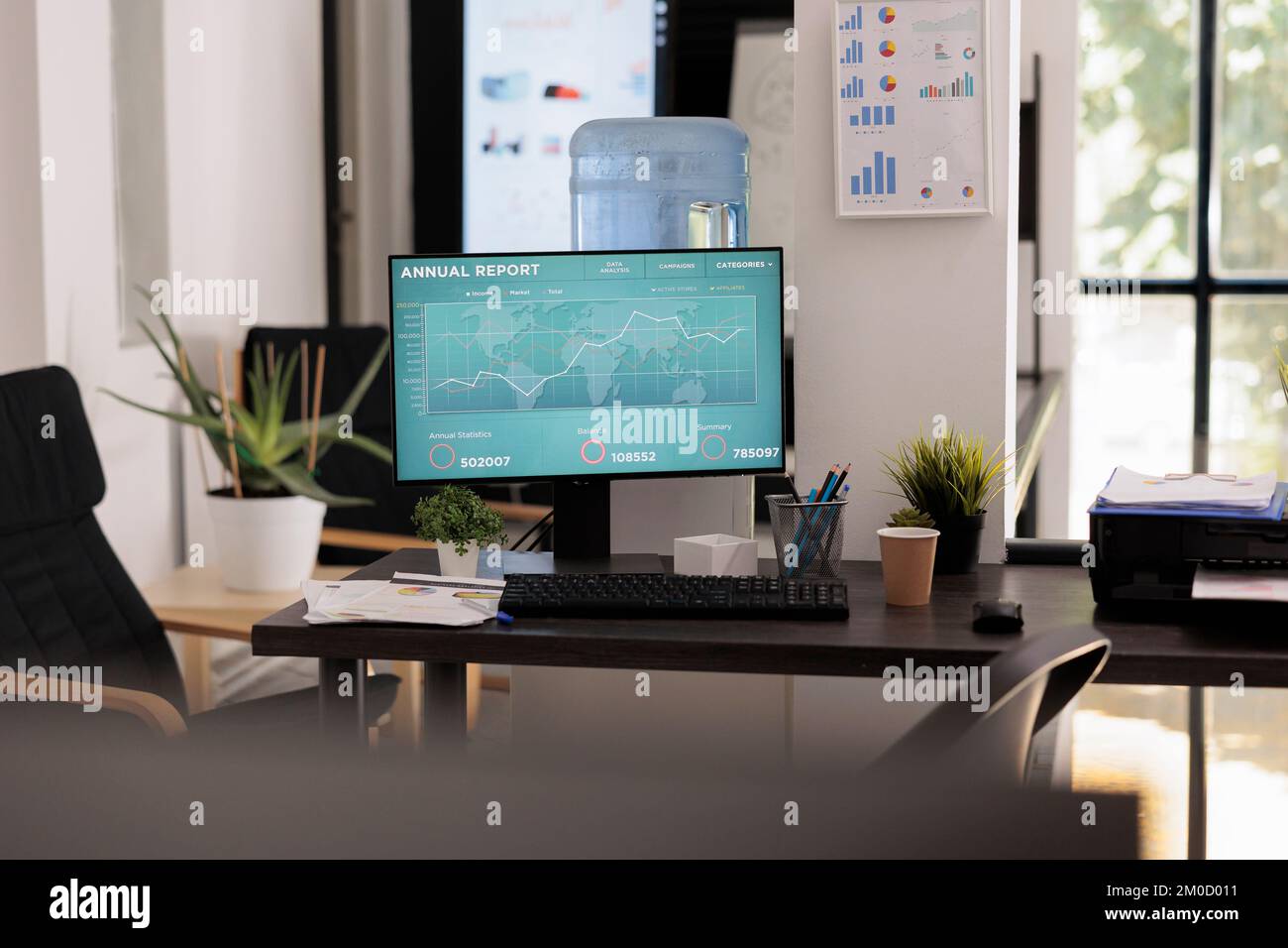 Monitor with analysis of business performance at office desk. Software showing trend of yearly ...