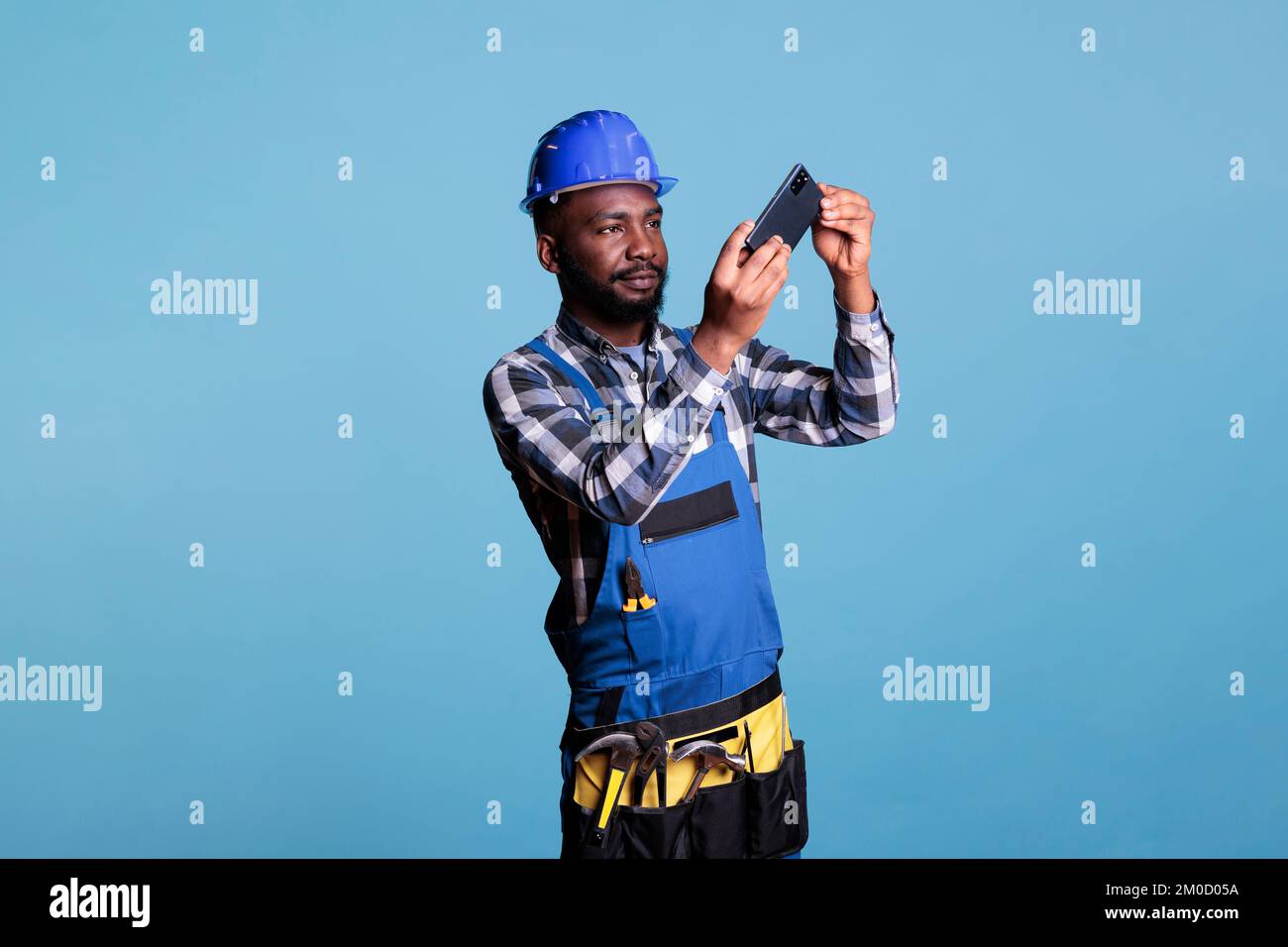 African american construction worker taking picture with mobile phone ...