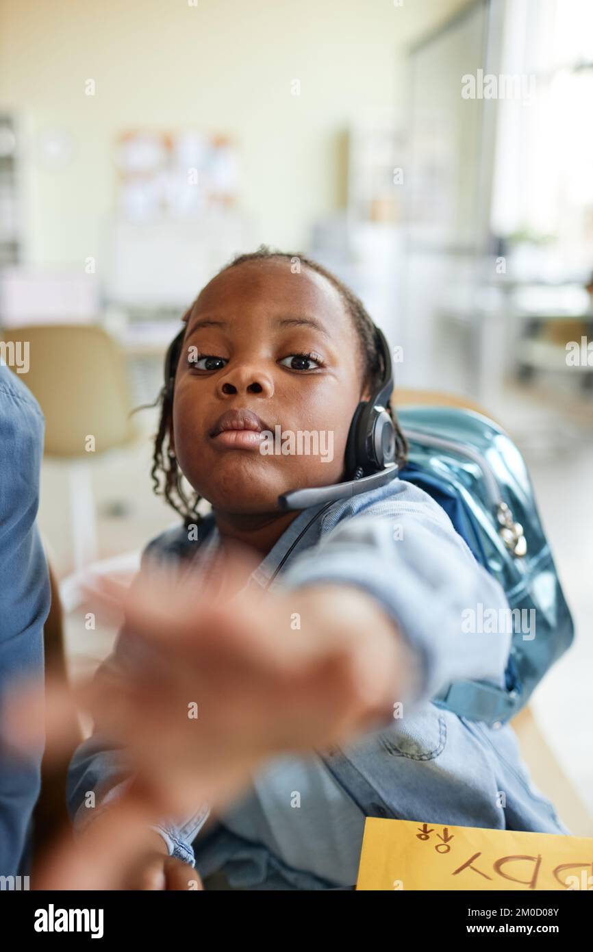 Vertical portrait of black child reaching to camera in home setting ...