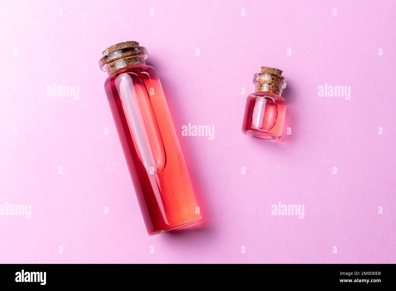 Pink essential rose or grapefruit citrus oil on pink background top ...