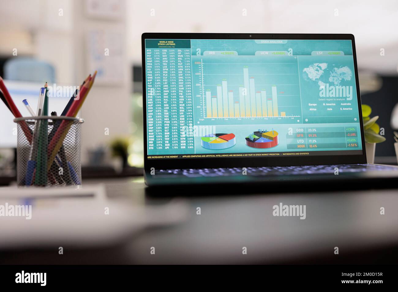 Stock market trade chart on laptop display on wooden table blurred ...