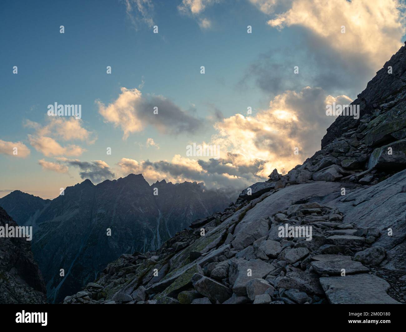 Dangerous rocky mountain path to the peak during summer sunset ...