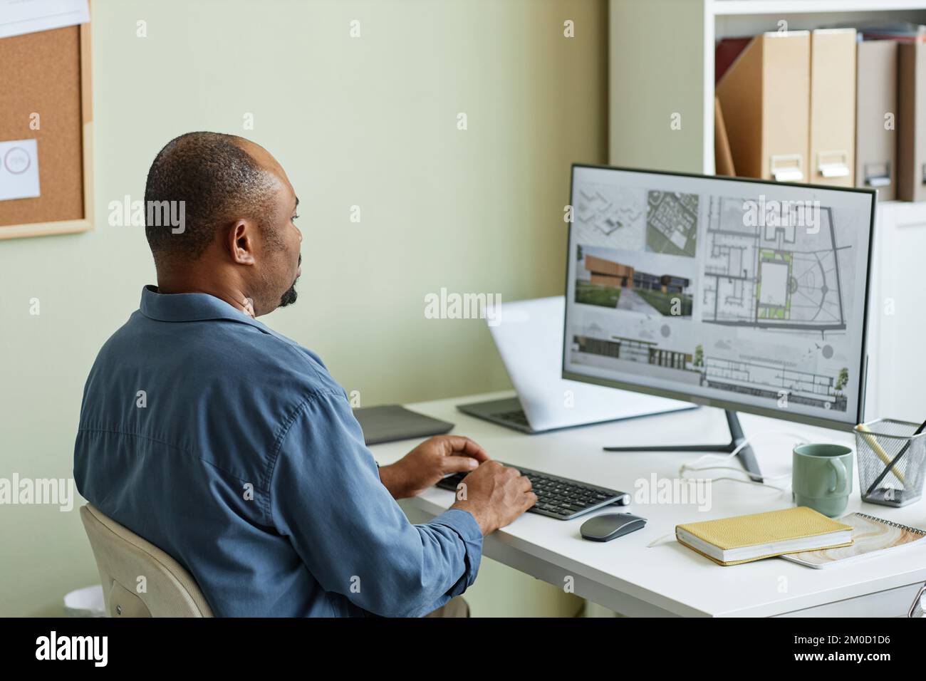 Side view portrait of black man as architect using computer and ...