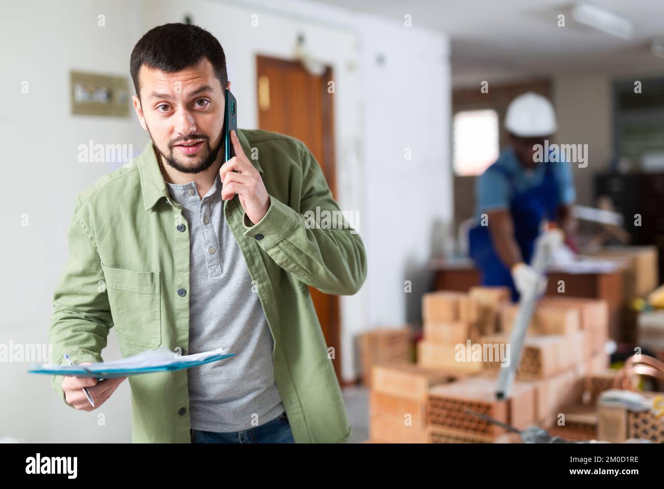 Owner of building under construction inspects the room being renovated ...