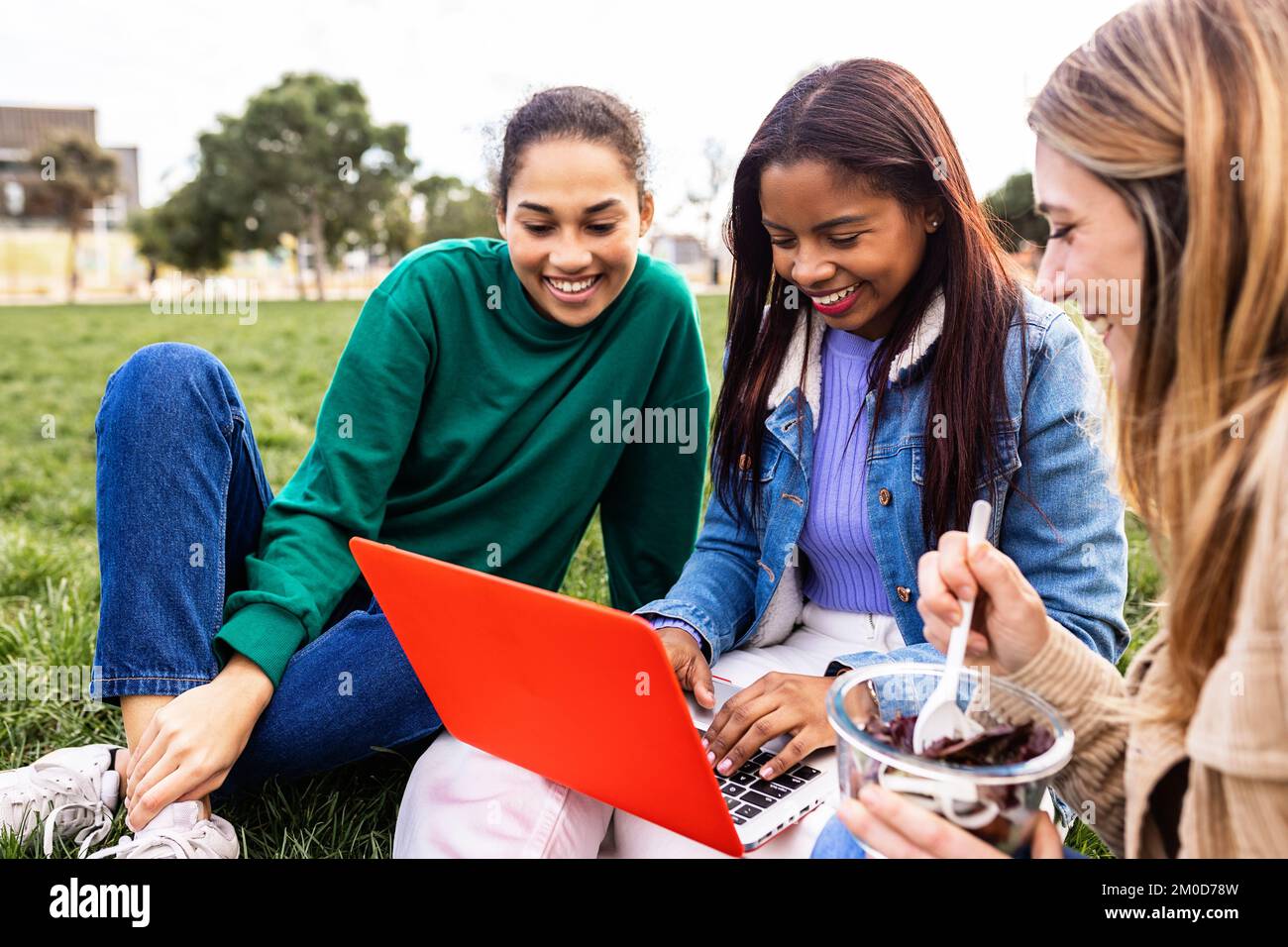 Young multiracial female students working together on laptop at college campus Stock Photo - Alamy