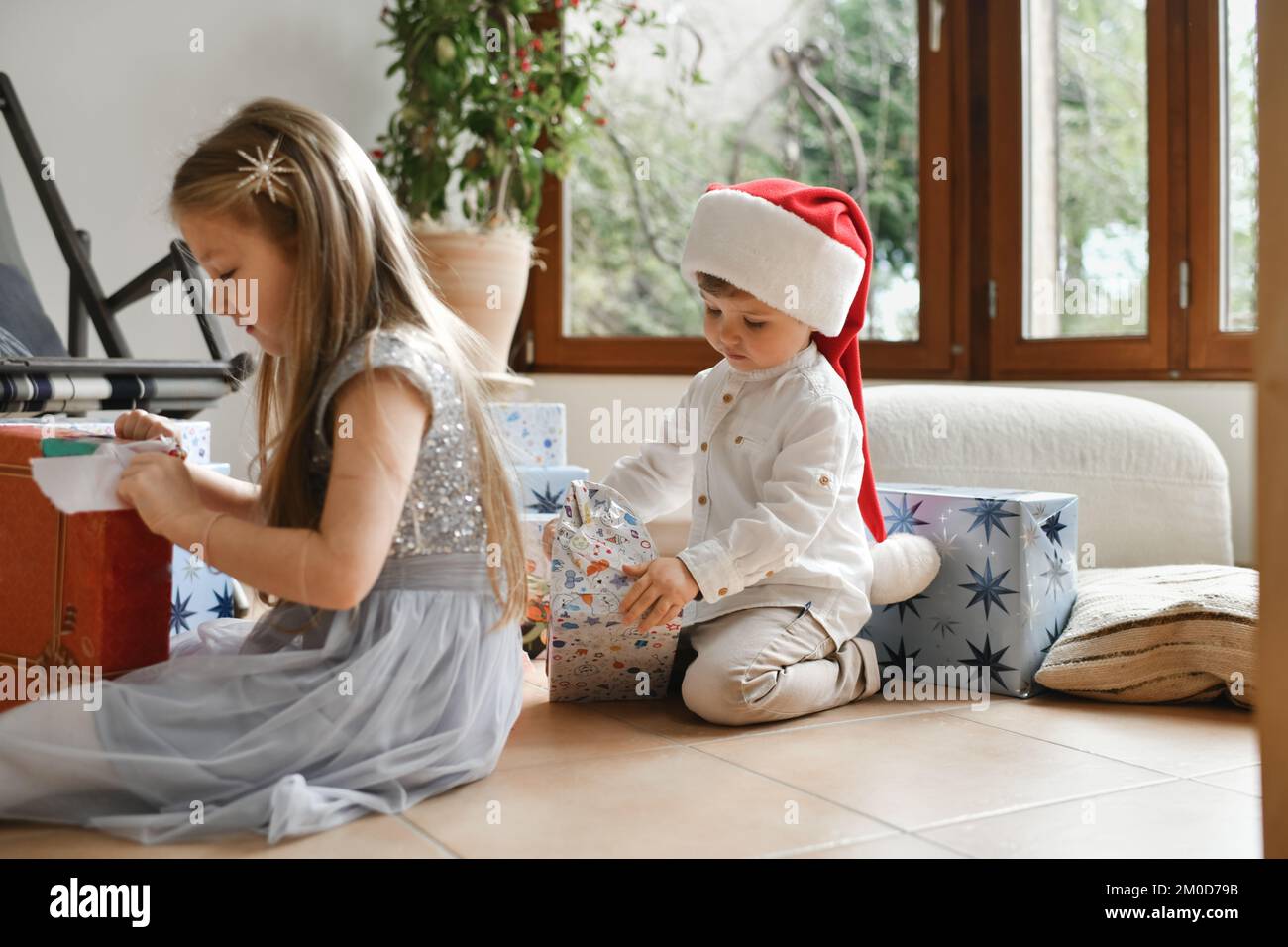 The brother and sister unwrapping christmas presents Stock Photo - Alamy
