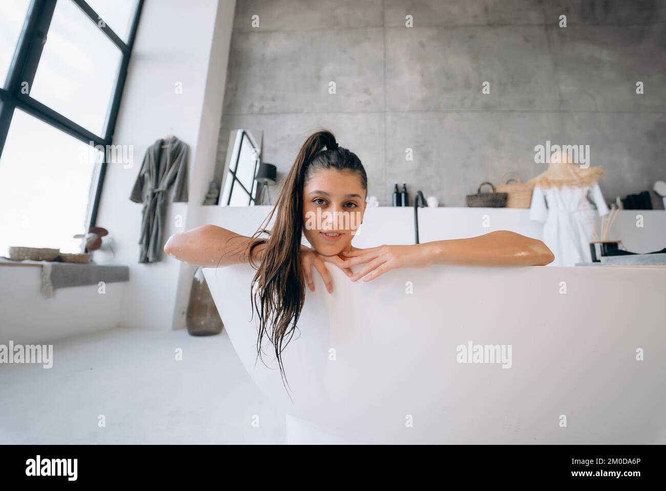 Relaxed lady taking bath, enjoying and relaxing while lying in bathtub ...