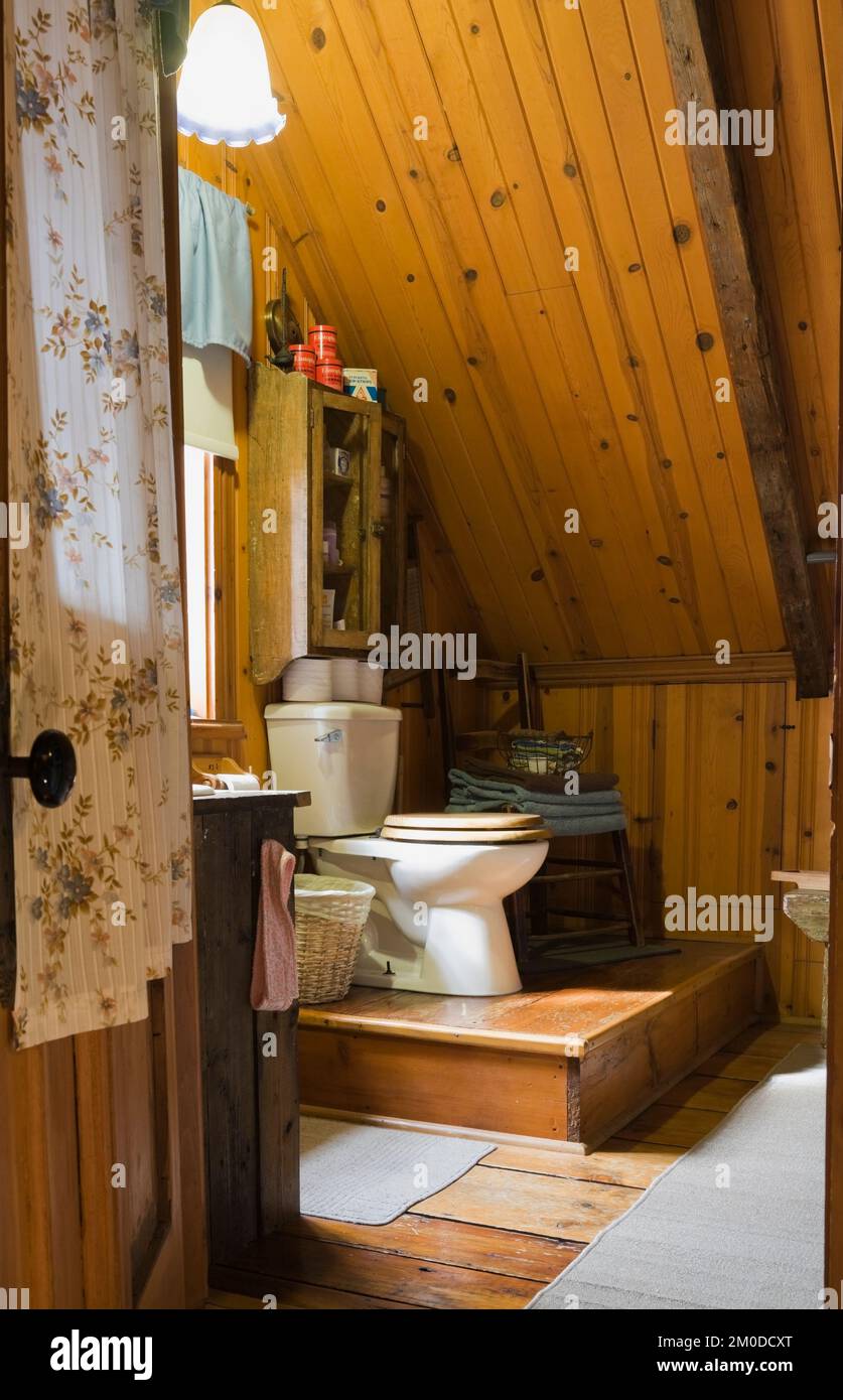Toilet with wooden seat and lid mounted on elevated wooden platform in ...