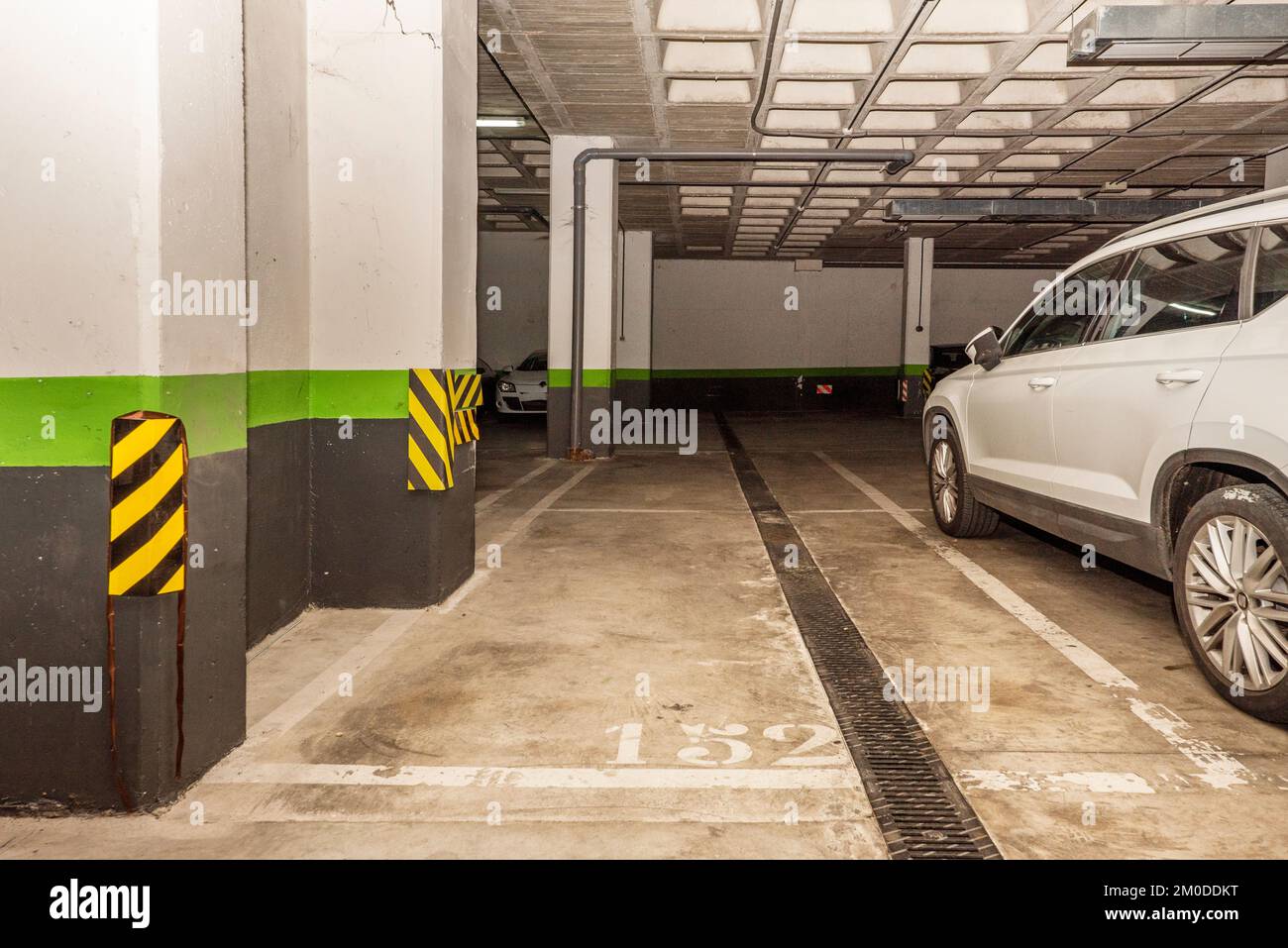 A garage with numbered empty parking spaces and anti-rub notices on the ...