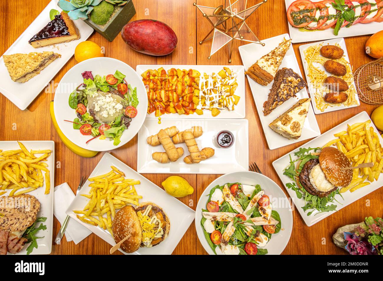 A table full of fast food dishes, salads, Venezuelan tequeños ...