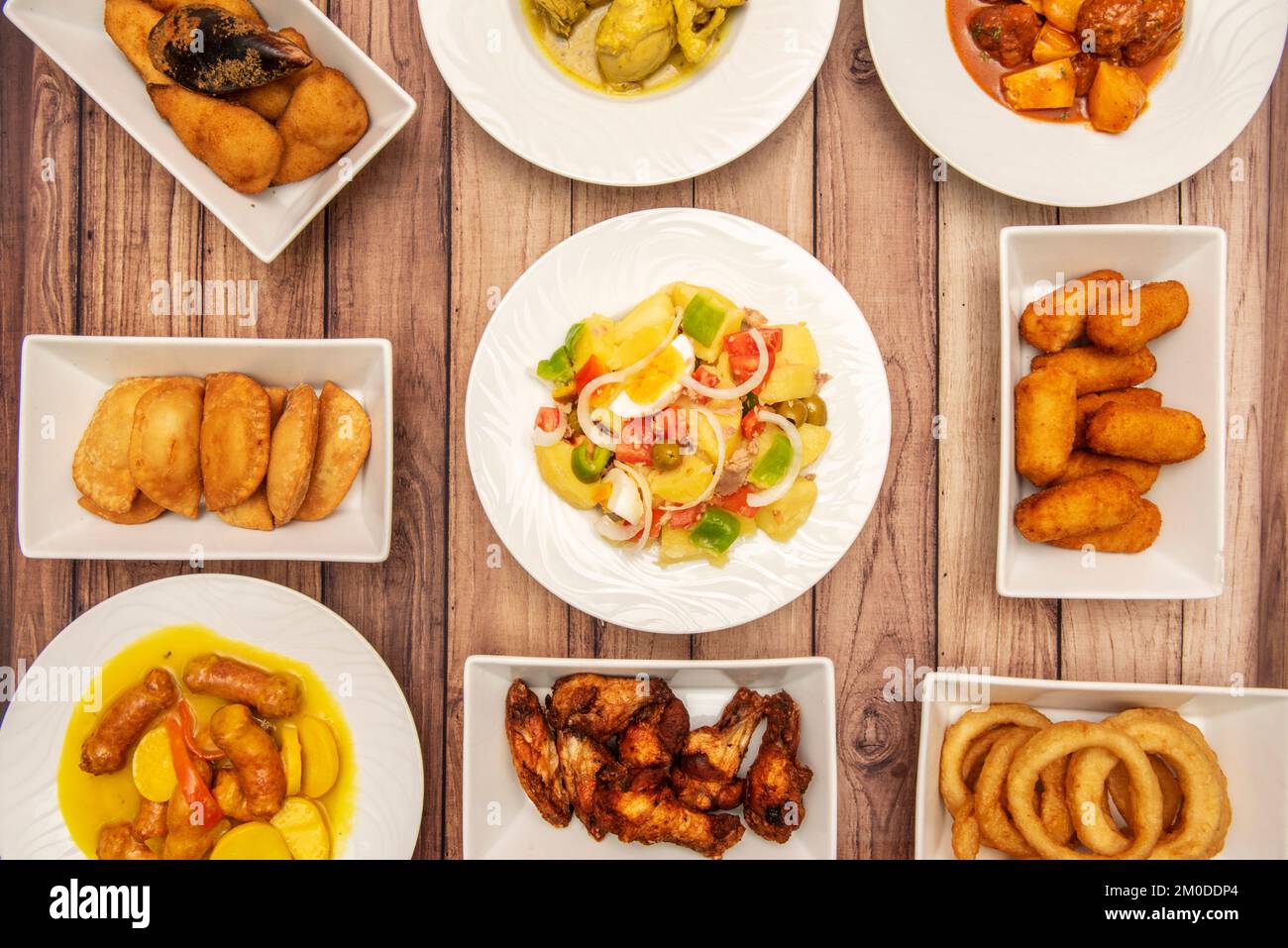 Typical Spanish tapas with peasant potato salad, serrano ham croquettes ...