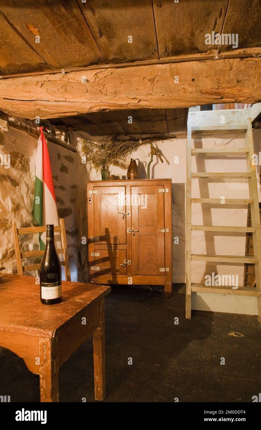 Bottle of wine on antique wooden table with high back chair and ...