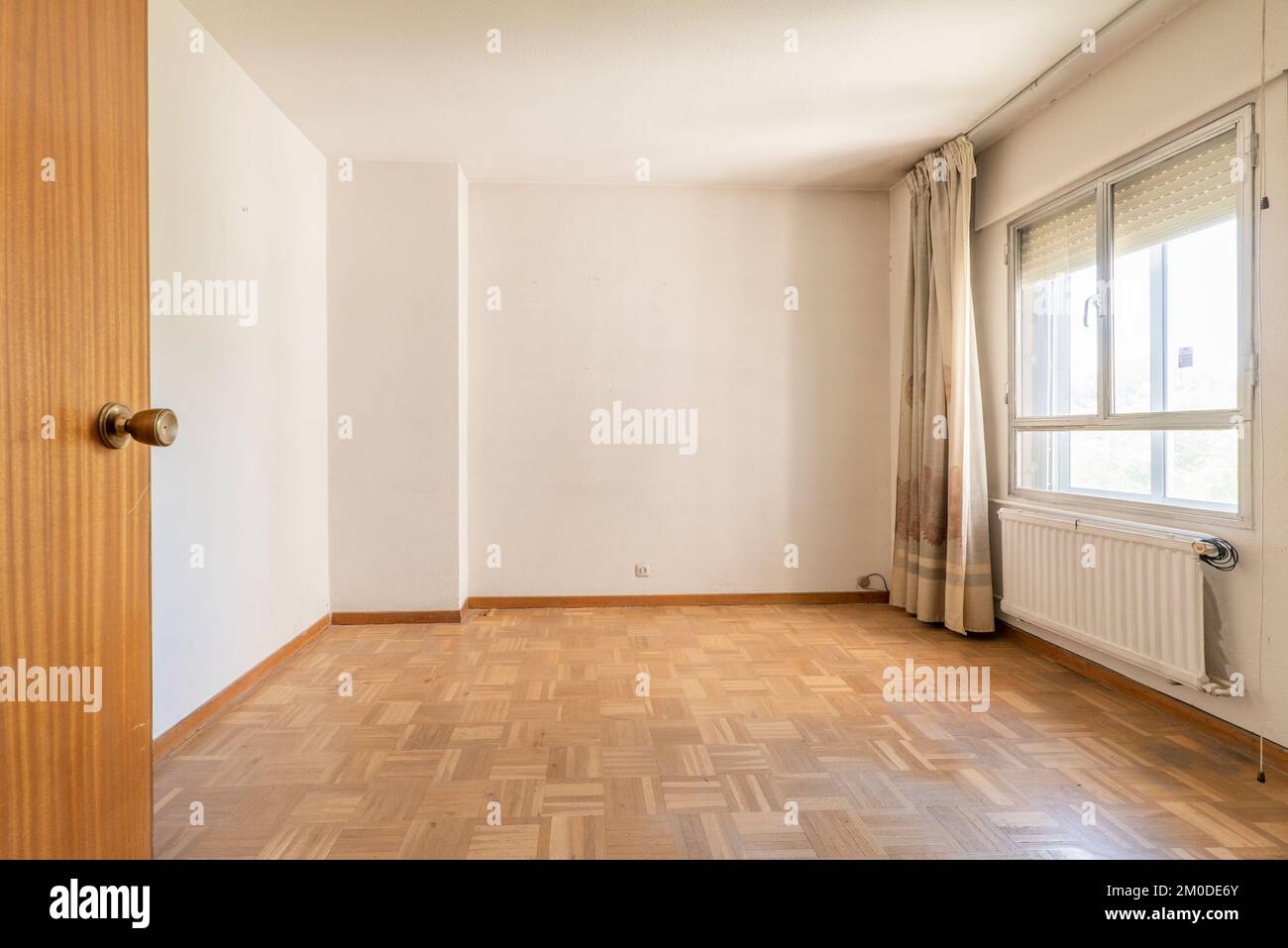 Empty room with checkerboard parquet flooring and window with old ...