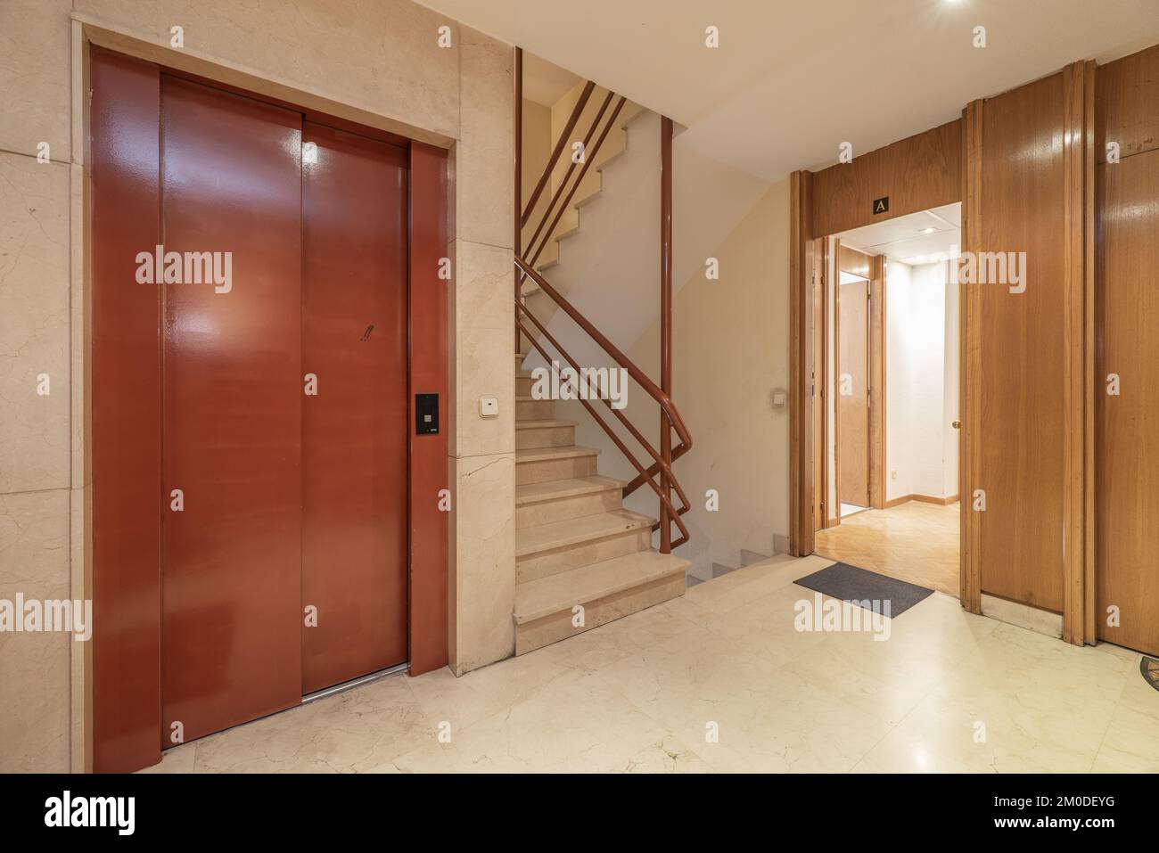 Landing of a residential building with elevators with red metal doors ...