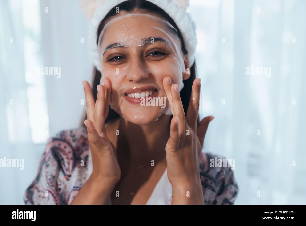 Beautiful model applying cosmetic cream treatment on her face Stock Photo - Alamy