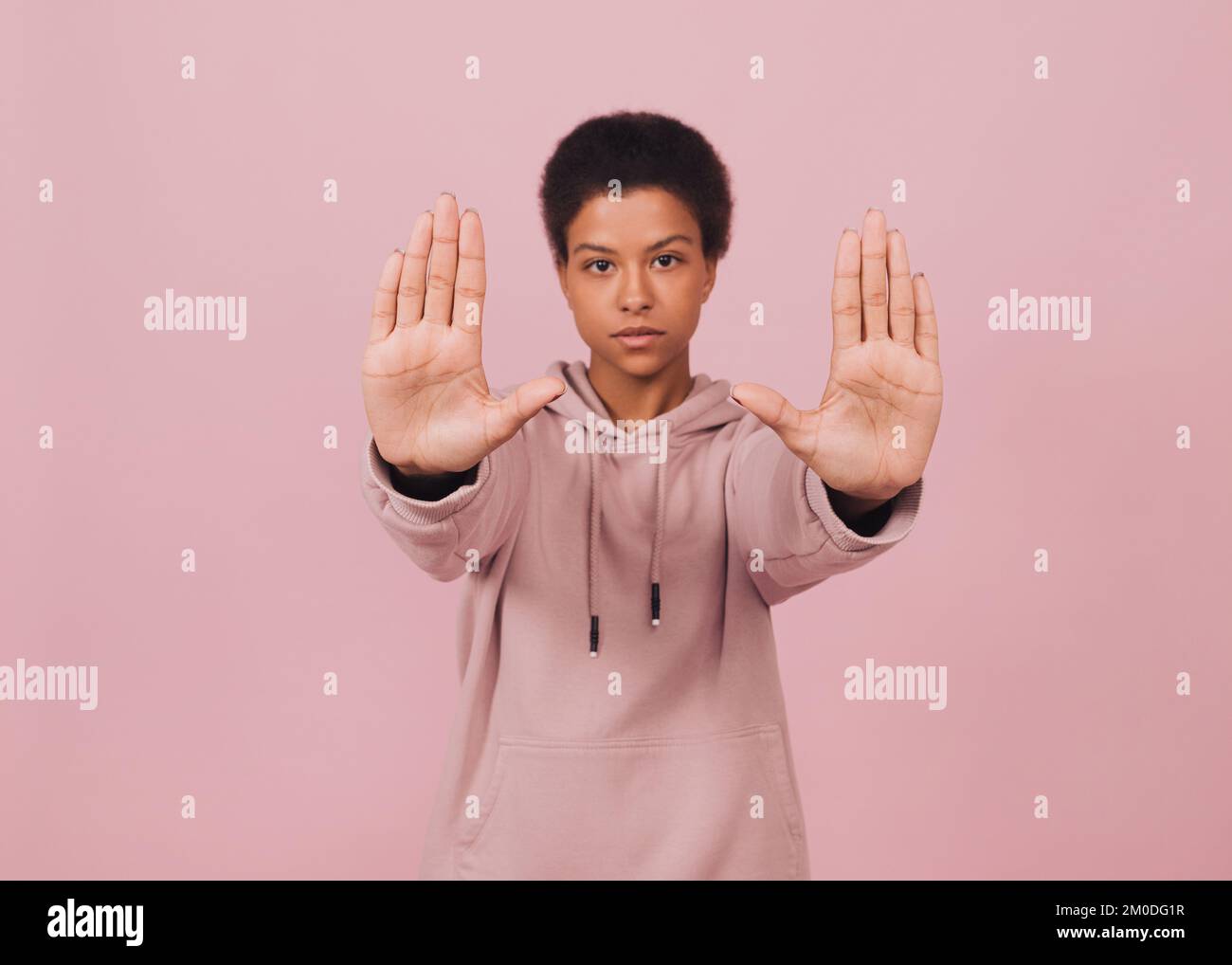 Serious black girl standing with stop gesture. Young afro woman with ...