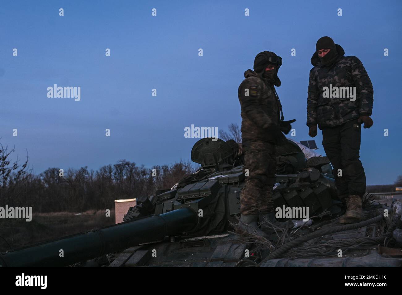 Two Ukrainian tank operators stand atop the hull of a Ukrainian tank in ...