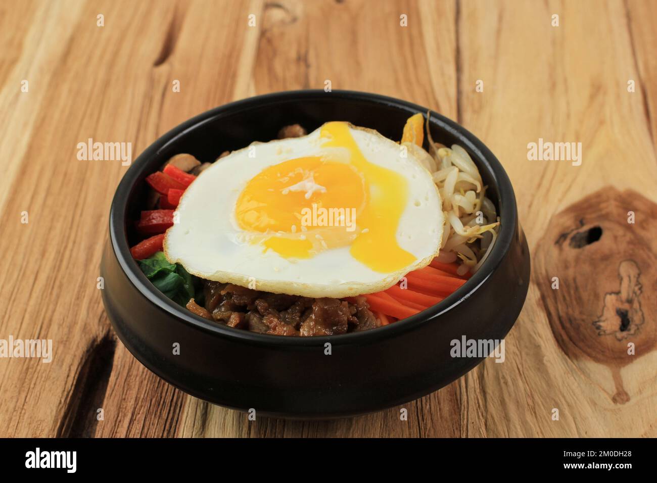 Bibimbap with Sunny Side Egg on a Wooden Background, Traditional Korean ...