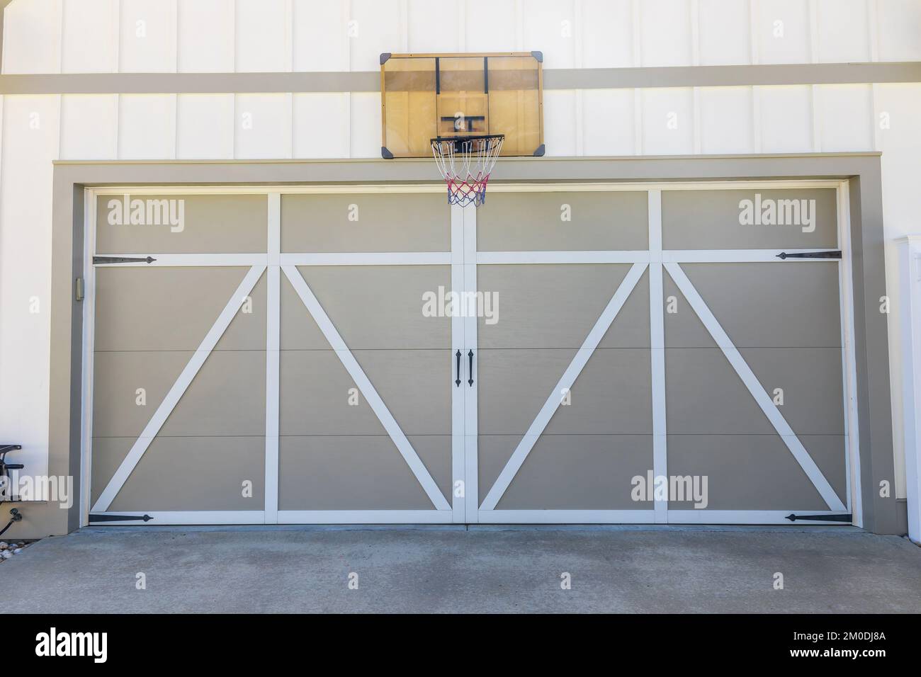 A basketball hoop mounted outside and above the garage of a new ...